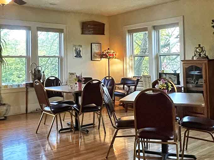Natural light streams through windows in this corner of the dining room, illuminating tables where countless celebrations have unfolded.