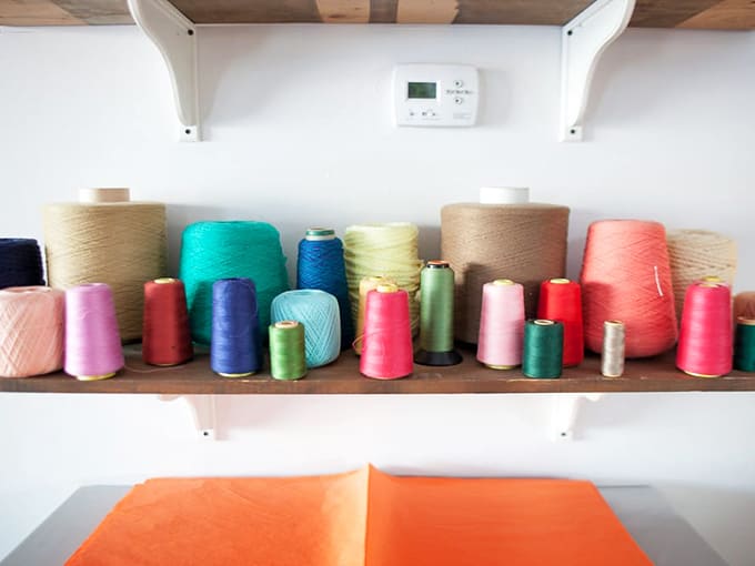 Spools of thread in candy colors stand like soldiers, ready to transform creative visions into handcrafted reality.