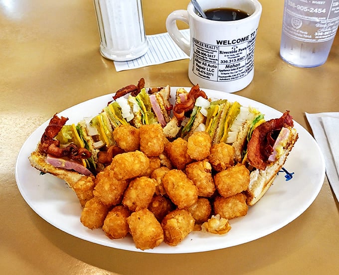 The club sandwich: architectural marvel of the diner world, surrounded by golden tater tots that crunch loud enough to turn heads.