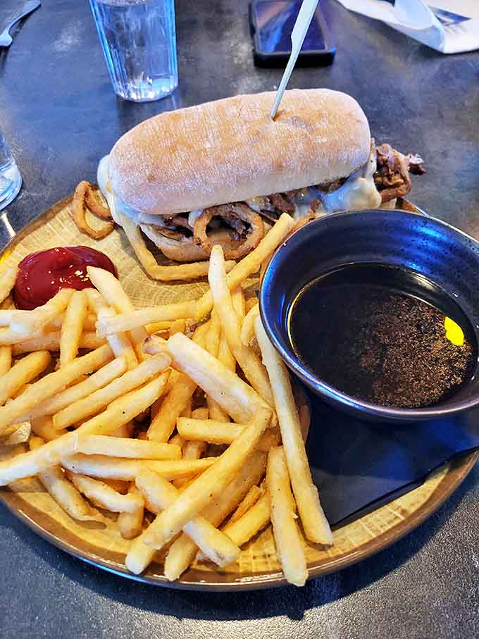 The French Dip arrives like a sandwich celebrity, complete with its own pool of au jus that's practically begging for a slow-motion dunk.