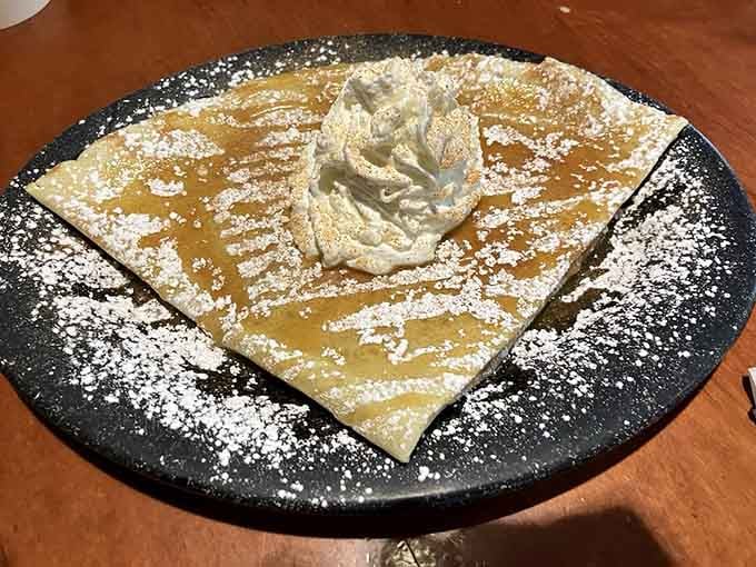 This isn't just a crepe &ndash; it's a powdered sugar landscape with whipped cream mountains that your fork can't wait to explore.