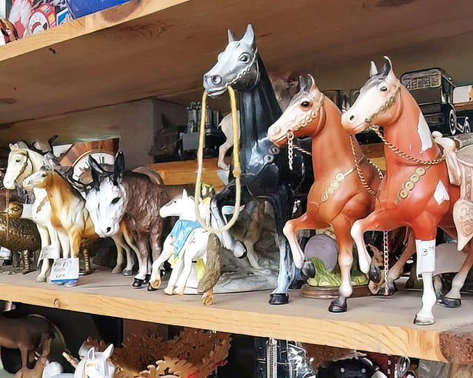 A stable of vintage horse figurines stands at attention, ready to gallop off to new homes. The one in black is definitely judging you.