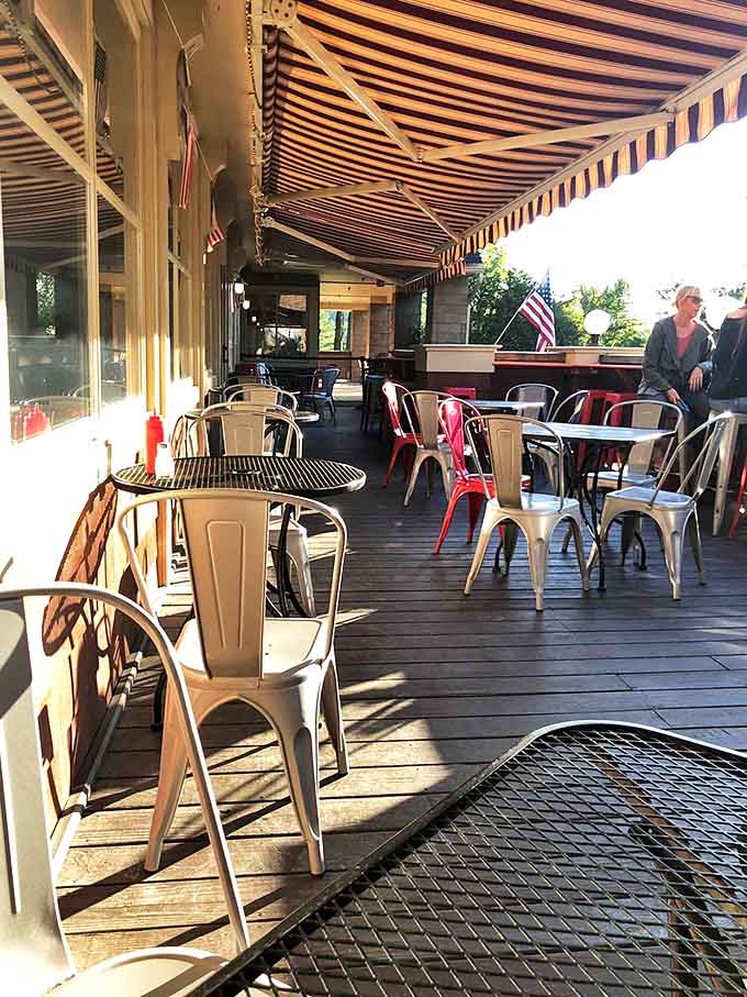 The outdoor patio offers al fresco dining under striped awnings, where summer breezes complement every bite and sip.