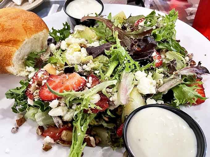 A salad that doesn't apologize for being healthy—it's too busy showing off with fresh greens, strawberries, and feta. The bread stands by, ready for dressing duty.