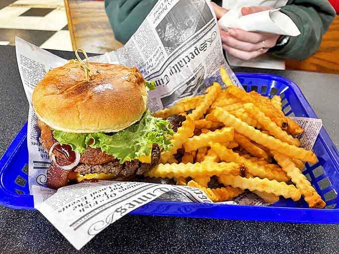 A proper diner burger served on newspaper—because good food should be headline news. Those crinkle fries deserve their own feature story.