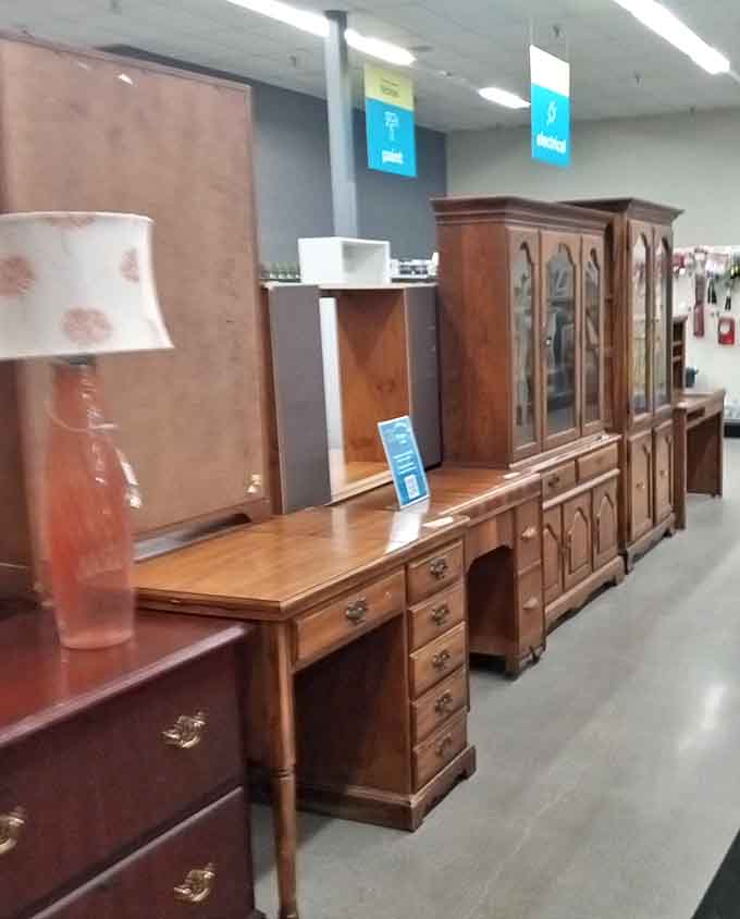 Executive desks and china cabinets line up like elegant soldiers, their solid wood construction and intricate details whispering tales of dinner parties past.