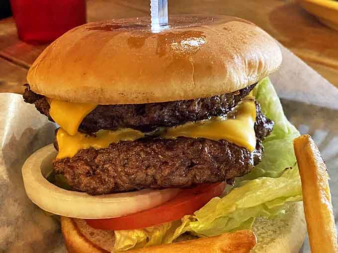 This isn't some fancy gastropub burger – it's the real deal, stacked high and proud, with cheese melting down the sides like a delicious waterfall.