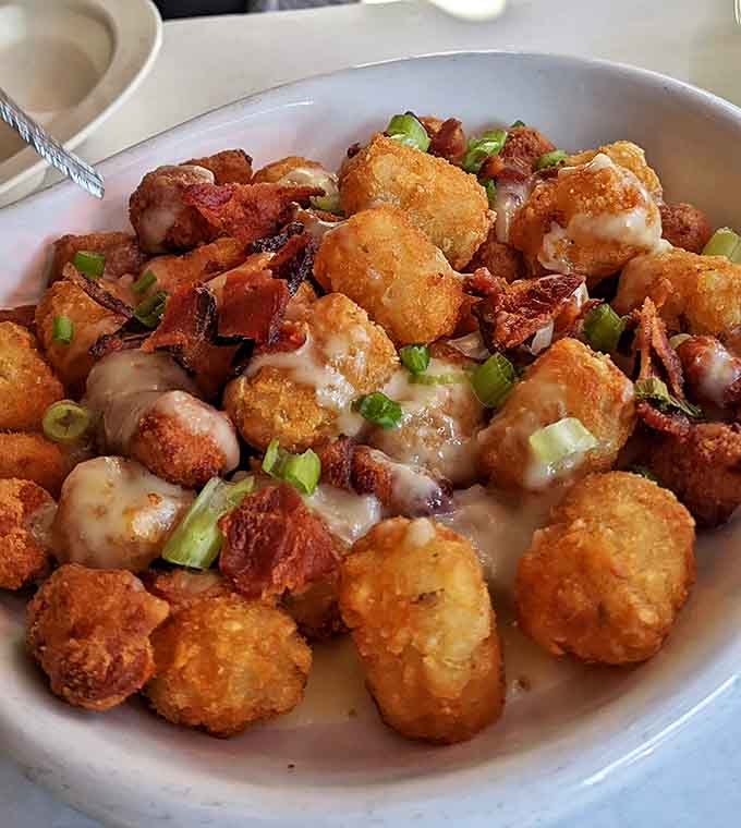 These loaded tots aren't just a side—they're a main event. Cheese, bacon, green onions—a flavor party where everyone's invited.