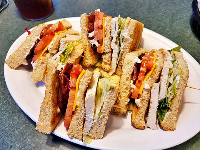 This club sandwich isn't playing around—stacked higher than my college debt and infinitely more satisfying to tackle.