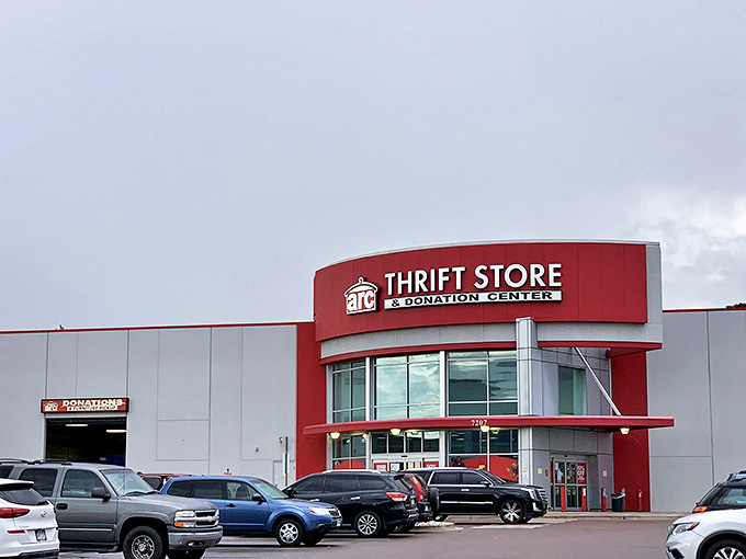 The unmistakable red signage of arc Thrift Store against a cloudy Colorado sky &ndash; a siren call to bargain hunters and treasure seekers alike.