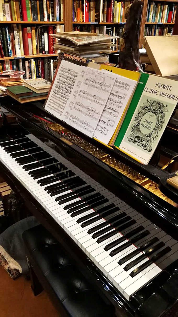 The grand piano waits patiently for someone to play while browsing sheet music. Bookstore or 19th-century salon? Why not both?