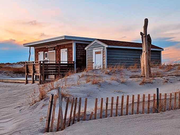 This weathered lifeguard station stands like a sentry at dusk, its wooden frame telling stories of countless summers and watchful eyes.