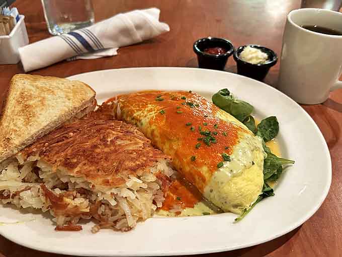 This omelet wears its cheese like a superhero cape, with hash browns playing the loyal sidekick. A breakfast dynamic duo that fights hunger crimes.