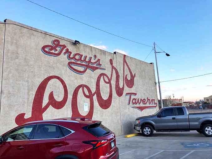 Classic cursive sprawls across weathered concrete, declaring this Gray's Pool Tavern territory in letters three feet tall.