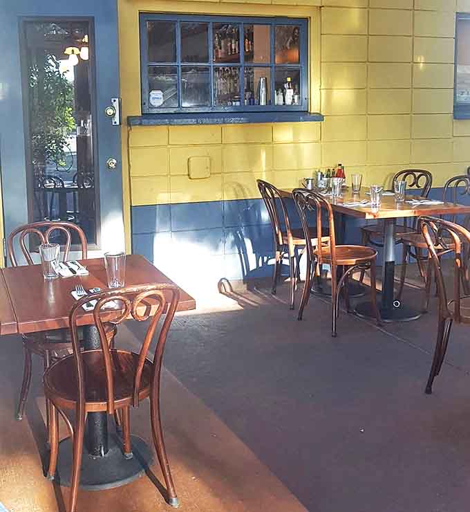 Sunshine streams through windows, illuminating the cheerful yellow and blue walls that frame your comfort food adventure.