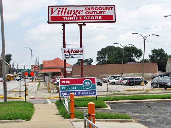 The roadside beacon that signals to passing bargain hunters: "Your wallet is safe here." A humble sign promising extraordinary possibilities within.