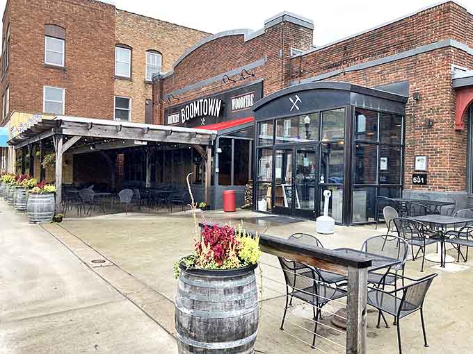 BoomTown Brewery's inviting patio features rustic barrel planters and outdoor seating, creating the perfect spot to sample local brews while watching Howard Street life unfold.
