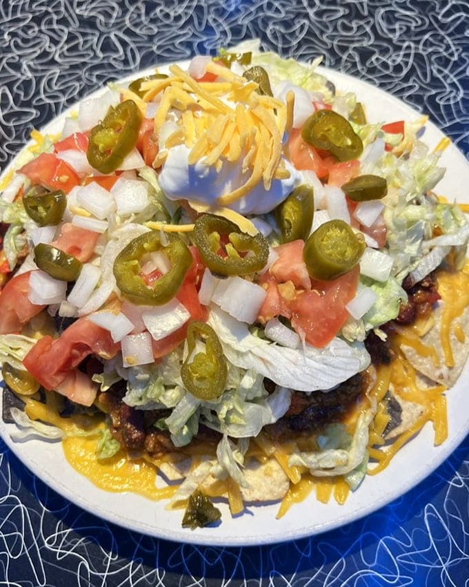 These loaded nachos reach toward the heavens with jalape&ntilde;os, cheese, and fresh veggies. Houston, we have no problems here.