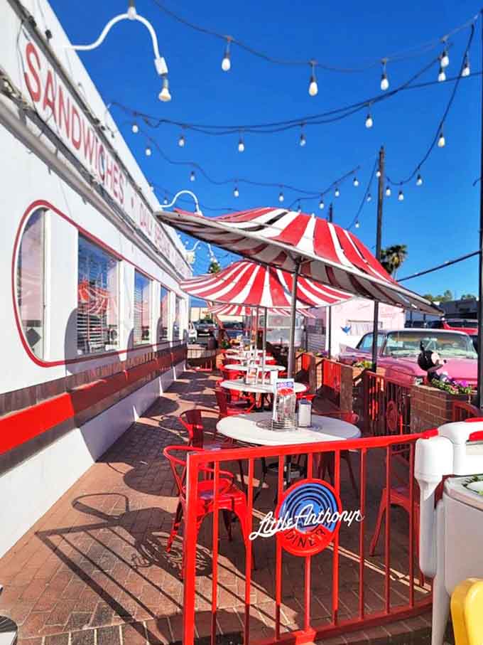 The outdoor patio with its red and white striped umbrellas &ndash; where Arizona sunshine meets 1950s charm for the perfect afternoon escape.