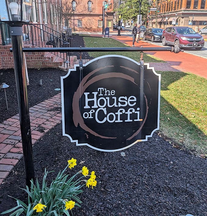 The sign says it all&mdash;House of Coffi, where that unique spelling hints at the distinctive experience waiting just beyond the daffodils and brick pathway.