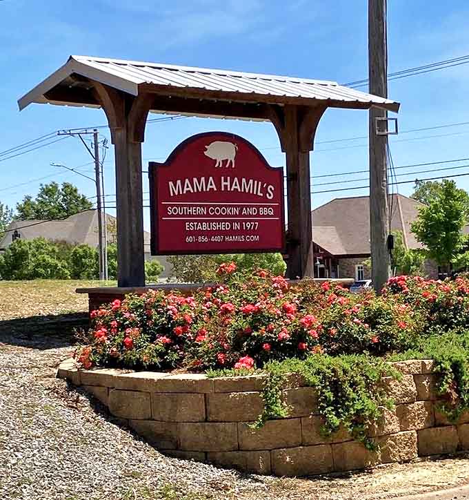 The sign that's launched a thousand road trips – surrounded by blooming roses, it stands as a beacon for hungry travelers seeking authentic Southern cooking.