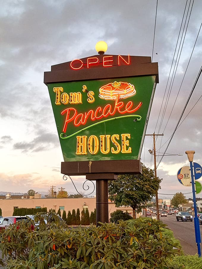 The neon sign glows like a lighthouse for the breakfast-starved, promising pancake salvation just ahead.