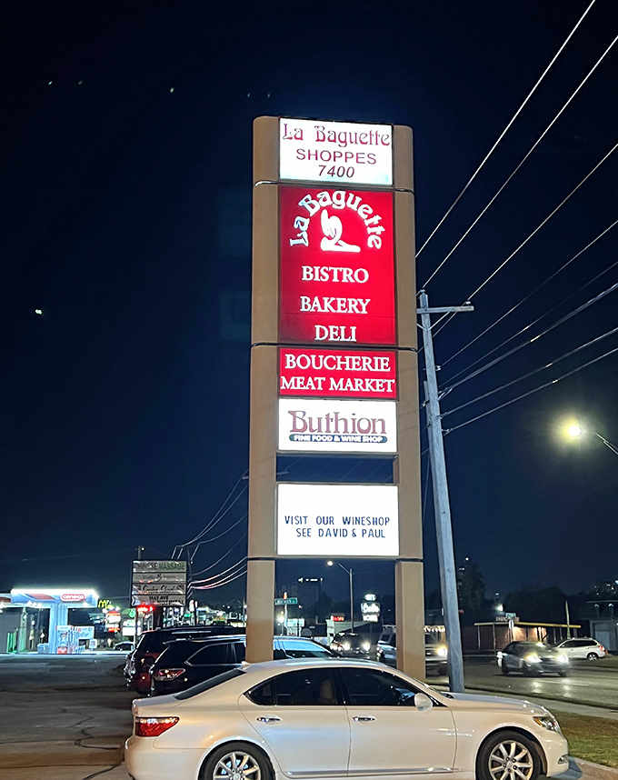At night, the illuminated sign serves as a beacon for hungry travelers seeking a taste of France in the heart of Oklahoma.