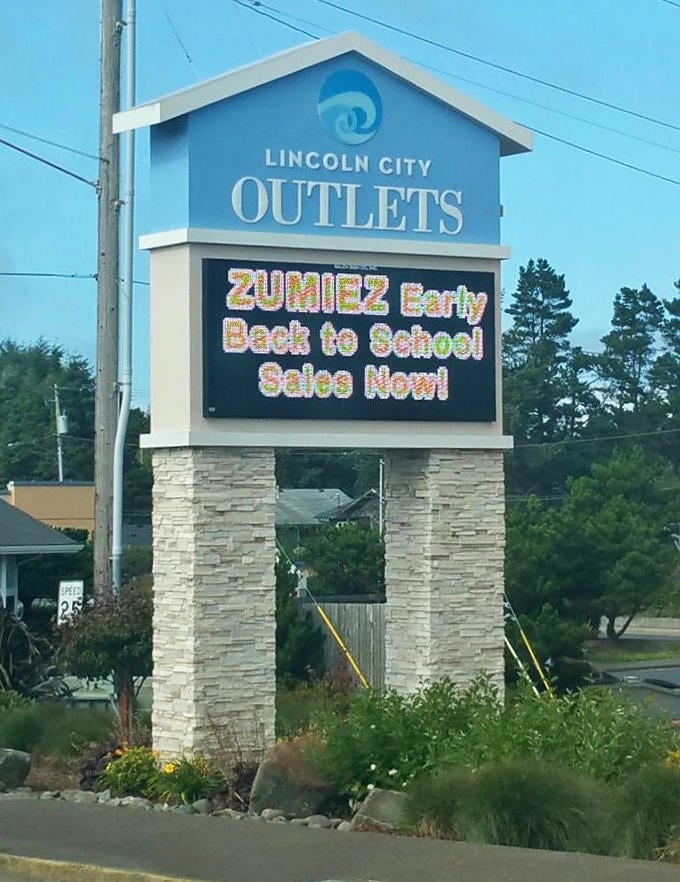 The digital marquee announces seasonal sales, beckoning highway travelers with promises of back-to-school bargains by the beach.