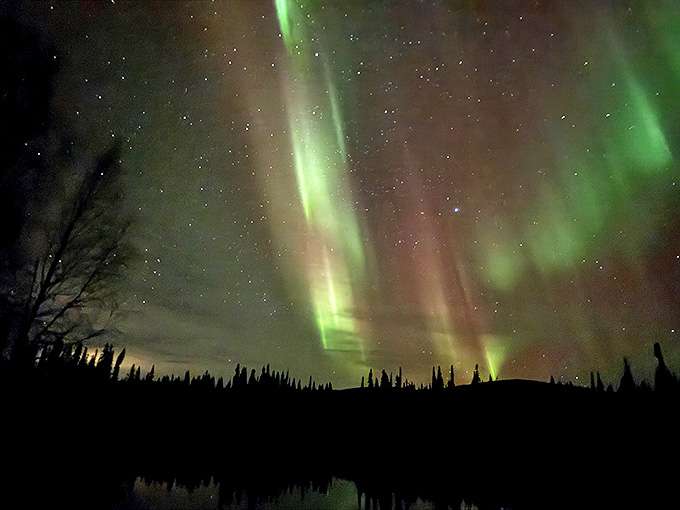 The northern lights performing their cosmic ballet, making every other light show on Earth look like amateur hour.