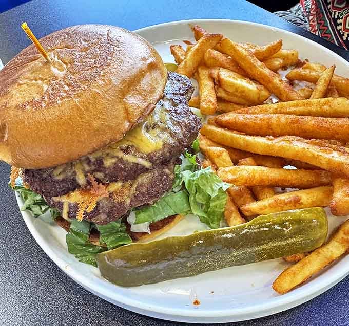 This isn't just a burger&mdash;it's a towering achievement of beef architecture with a pickle sentinel standing guard beside golden fry soldiers.