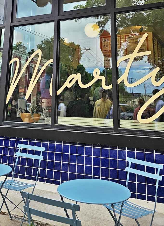 Those blue bistro chairs aren't just outdoor seating&mdash;they're front-row seats to the neighborhood's comings and goings, sandwich in hand.