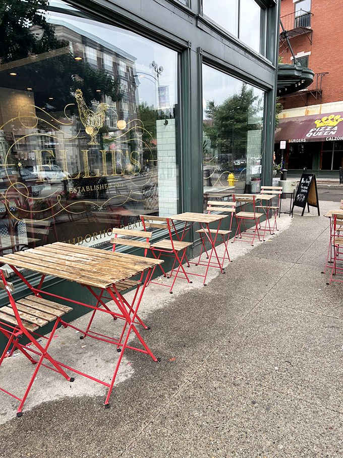 Sidewalk seating with charming red frames invites you to people-watch while savoring your breakfast sandwich&mdash;urban dining at its finest.