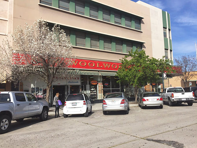 Even the parking area feels nostalgic, with the Woolworth sign standing guard over vehicles from every decade—proof that good taste never goes out of style.