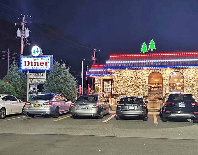 By night, Twin Pines transforms into a glowing beacon of comfort food possibilities, its neon and string lights promising delicious refuge from the world.