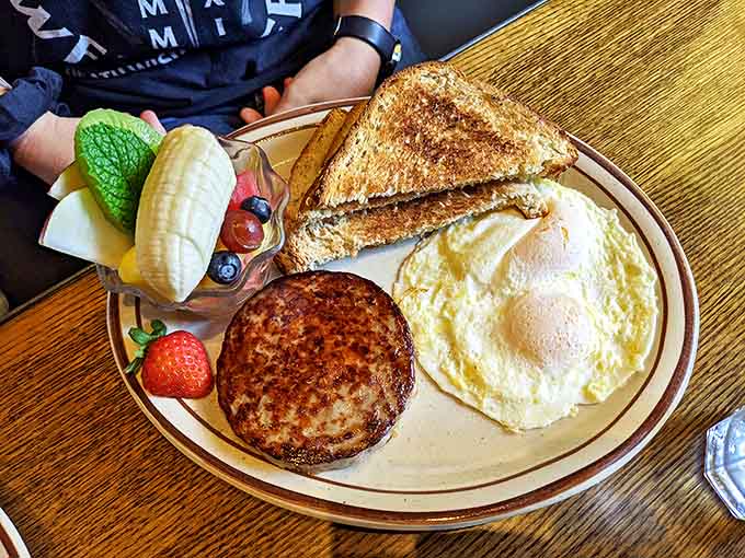 Morning perfection on a plate &ndash; where eggs, sausage, and toast perform a breakfast ballet accompanied by fresh fruit backup dancers.