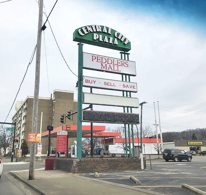 The Central City Plaza sign stands tall, directing bargain hunters to their destination with the simple promise that defines the Peddlers Mall experience: "Buy. Sell. Save."