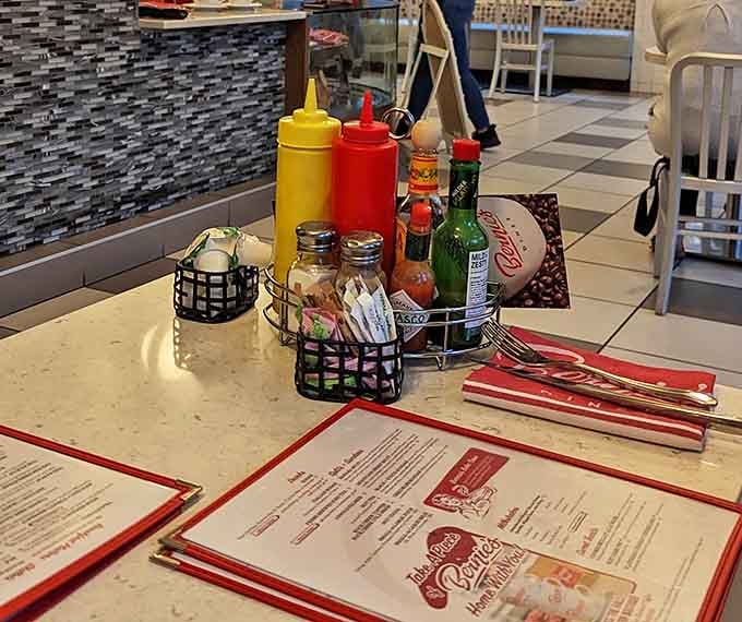 The condiment caddy—that unsung hero of diner dining. Hot sauce, ketchup, and mustard standing at attention, ready for duty.