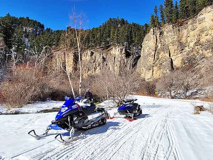 Winter transforms the canyon into a snowmobile playground. These machines aren't just parked – they're catching their breath between adventures.