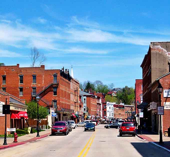 Main Street rolls downhill like a scene from "It's a Wonderful Life," red brick buildings glowing under blue skies.