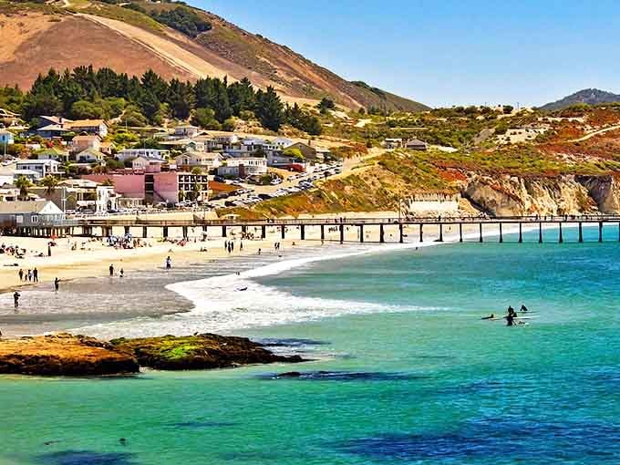 Grover Beach's wooden pier stretches into turquoise waters where surfers catch waves and families build sandcastles.