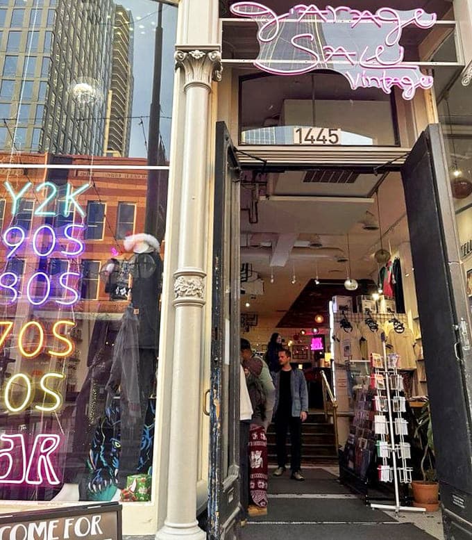 The pink neon glow beckons like a lighthouse for the fashion-forward treasure hunter. Denver's historic architecture frames this modern-day gold mine.