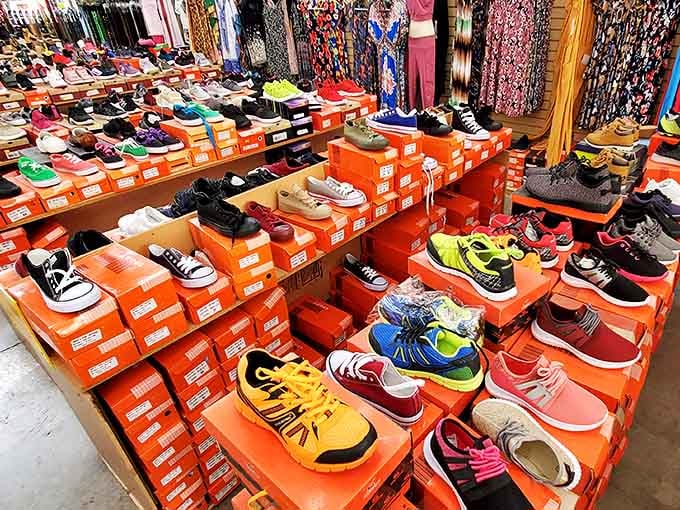 A rainbow of footwear possibilities stacked neatly on orange boxes. Finding your perfect pair here feels like winning the shoe lottery!