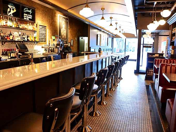 The sleek bar stretches like a luxury rail car, inviting you to pull up a stool and settle in for a journey of flavors without leaving Iowa City.