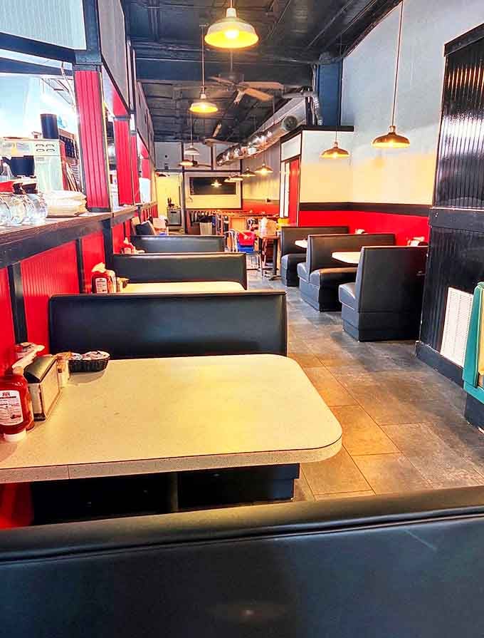 Classic blue booths and red walls create that perfect diner atmosphere where conversations flow as freely as the coffee. Comfort begins before you even order.