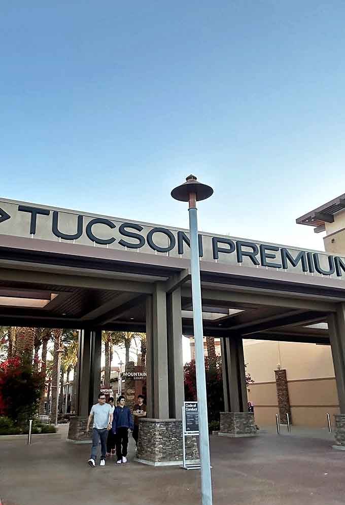 Shoppers pass through the welcoming archway, where palm trees and Southwestern design elements set the stage for a day of bargain hunting.