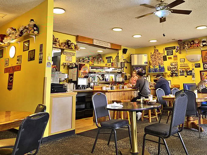 Teddy bears stand sentinel over diners from every shelf and surface, creating a whimsical yellow sanctuary where comfort food reigns supreme.