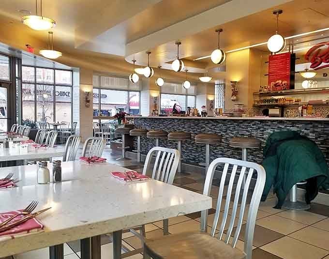 Sleek marble countertops meet retro diner charm in Bernie's bright interior, where pendant lighting creates the perfect ambiance for serious eating.