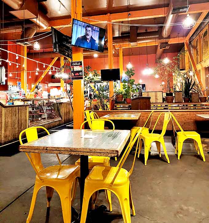 Inside, those yellow chairs pop against warm wood tones, creating the perfect backdrop for the meat-centric drama about to unfold on your plate.