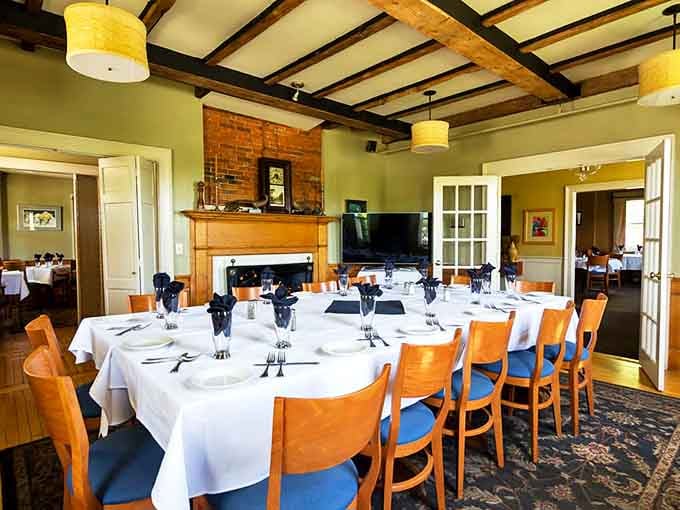 Exposed wooden beams and a brick fireplace create that rare dining alchemy: a room that feels both special occasion-worthy and comfortably familiar.