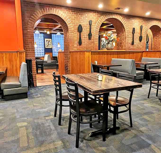 Warm brick archways and wooden accents create the perfect breakfast sanctuary. Those oversized utensils on the wall? A not-so-subtle hint that serious eating happens here.